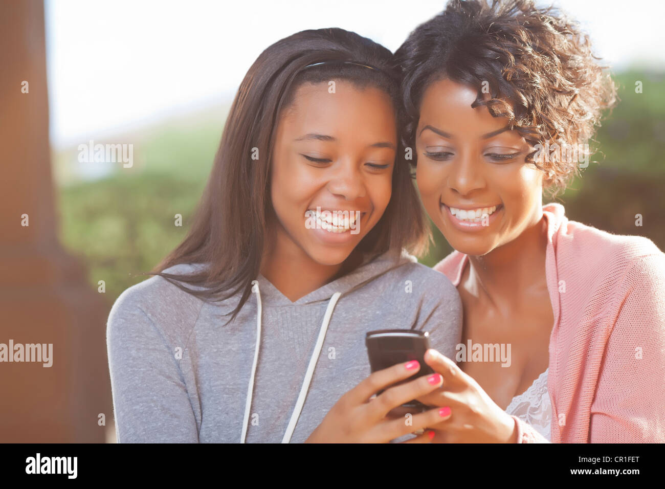Mother and daughter using cell phone Stock Photo - Alamy
