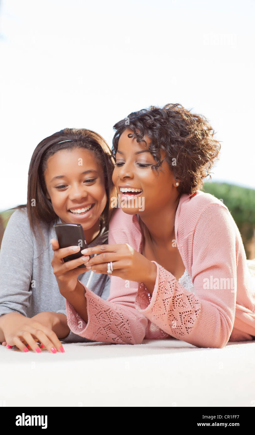 Mother and daughter using cell phone Stock Photo - Alamy