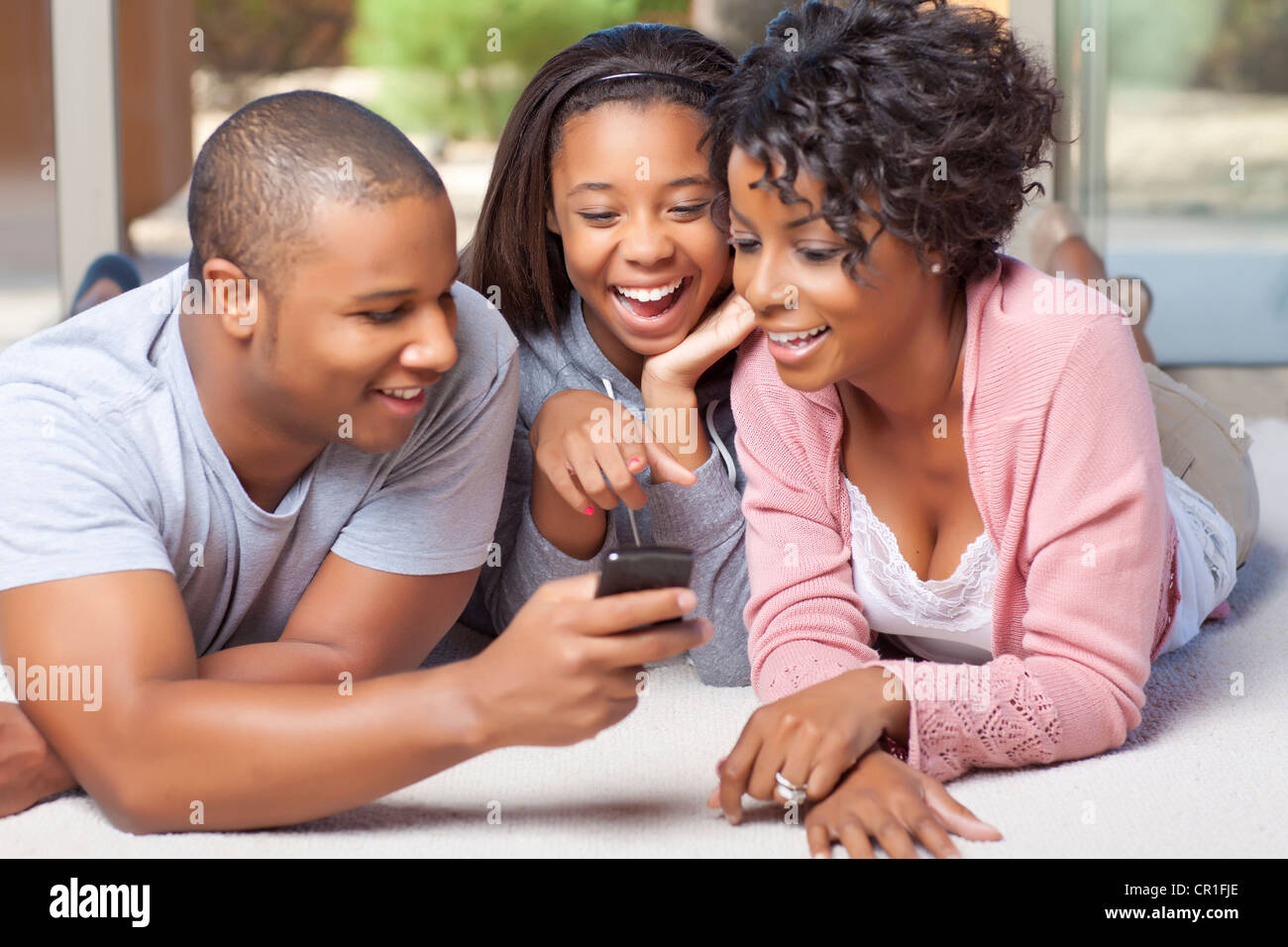 Smiling family using cell phone together Stock Photo - Alamy