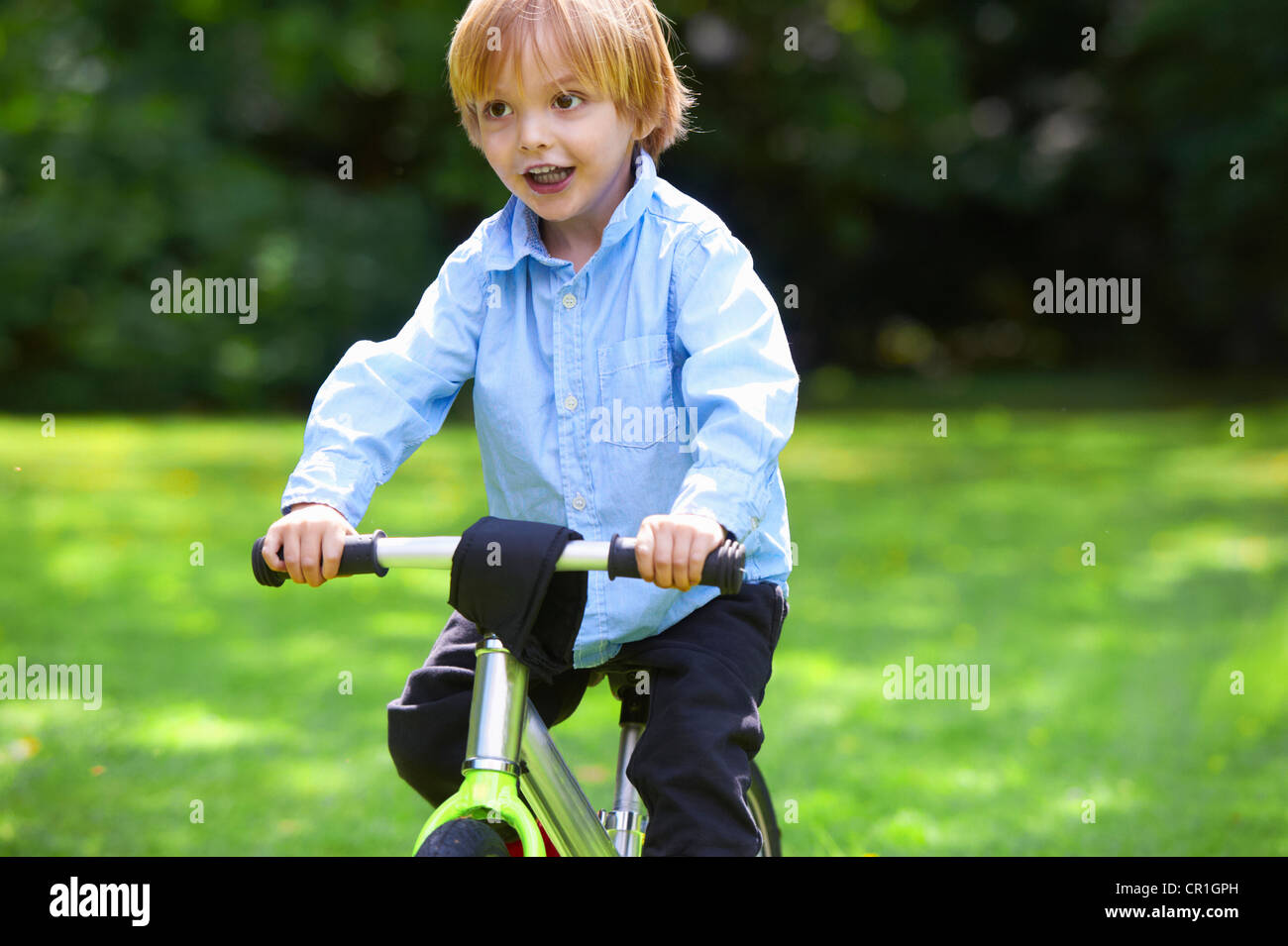 Boy riding bicycle in backyard Stock Photo - Alamy