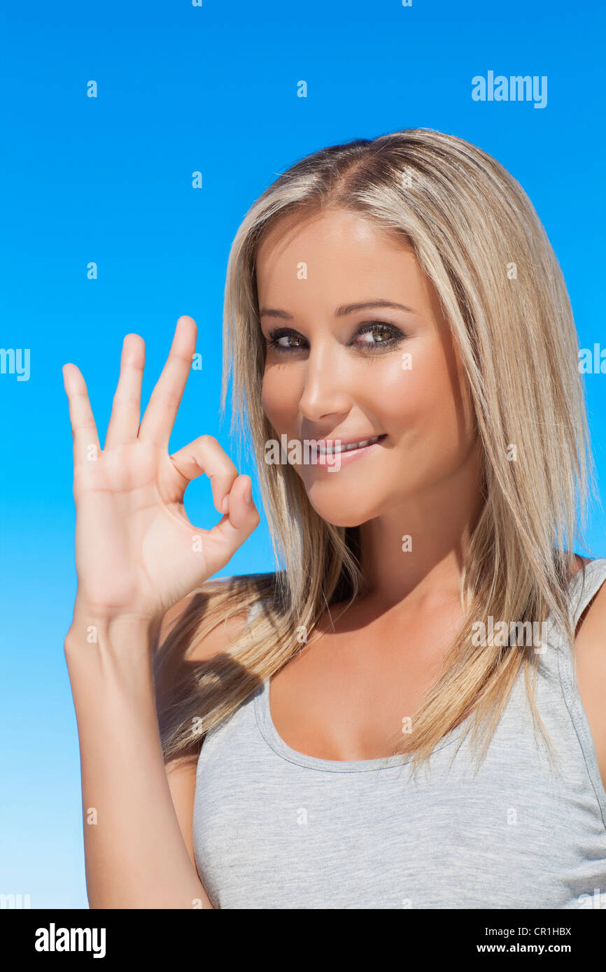 Smiling woman making OK sign Stock Photo - Alamy