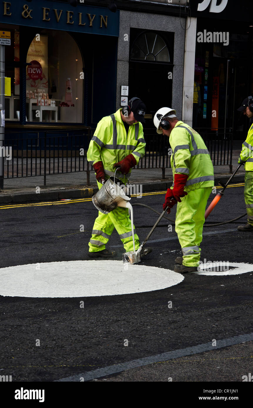 Men walking round in ever-increasing circles, painting a traffic ...