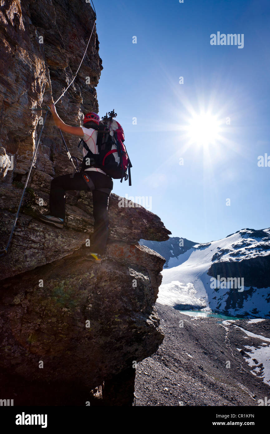 Hiker climbing to the top of Tschenglser Hochwand, on the fixed rope ...