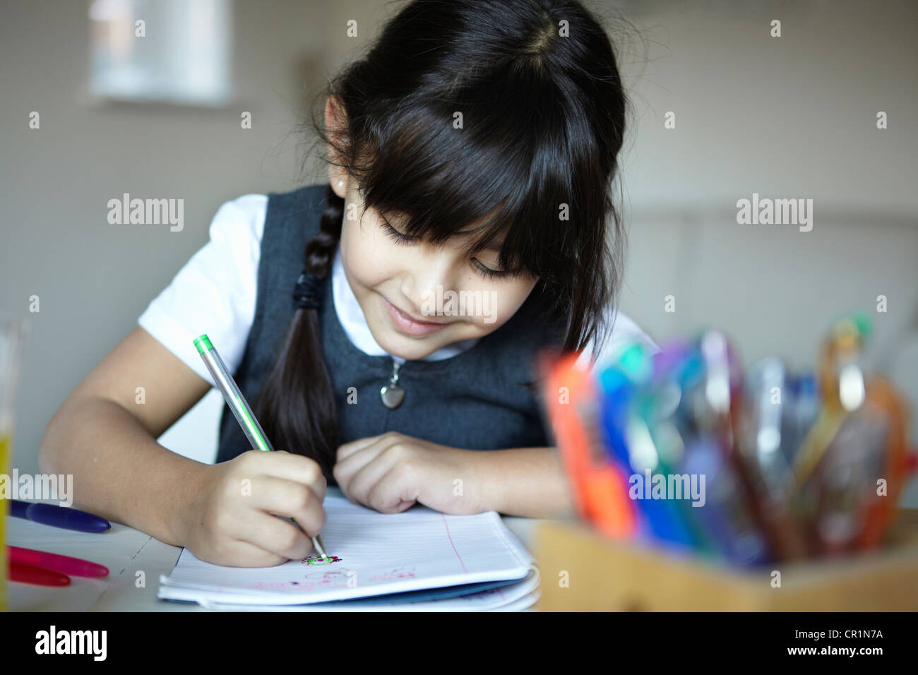 Schoolgirl writing at desk Stock Photo - Alamy