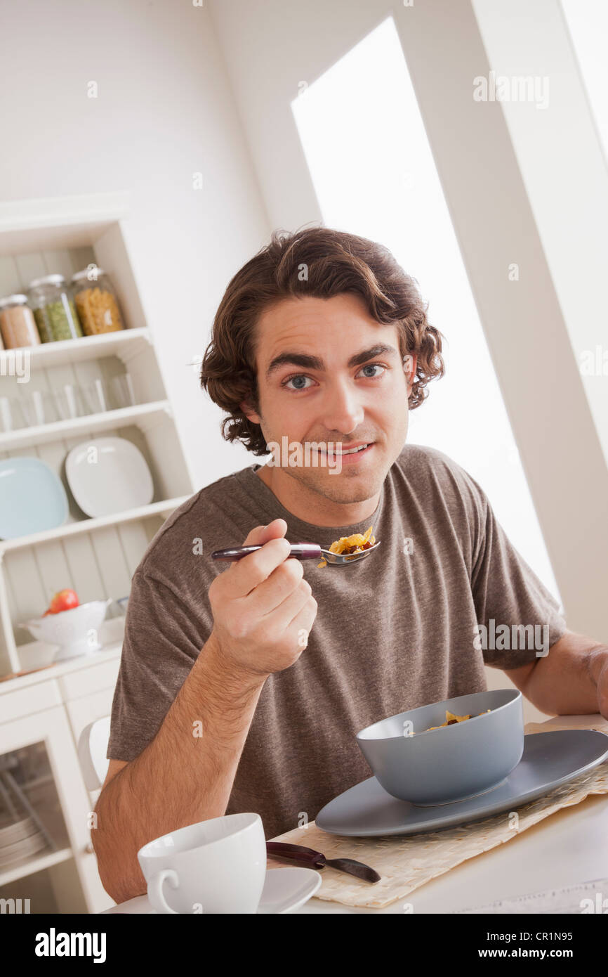 USA, California, Los Angeles, Portrait of young man eating breakfast ...