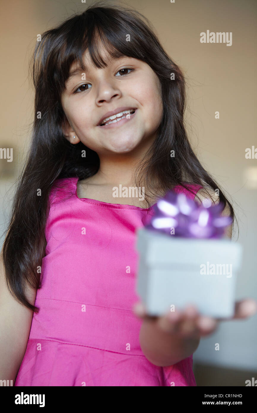 Girl offering wrapped gift Stock Photo - Alamy