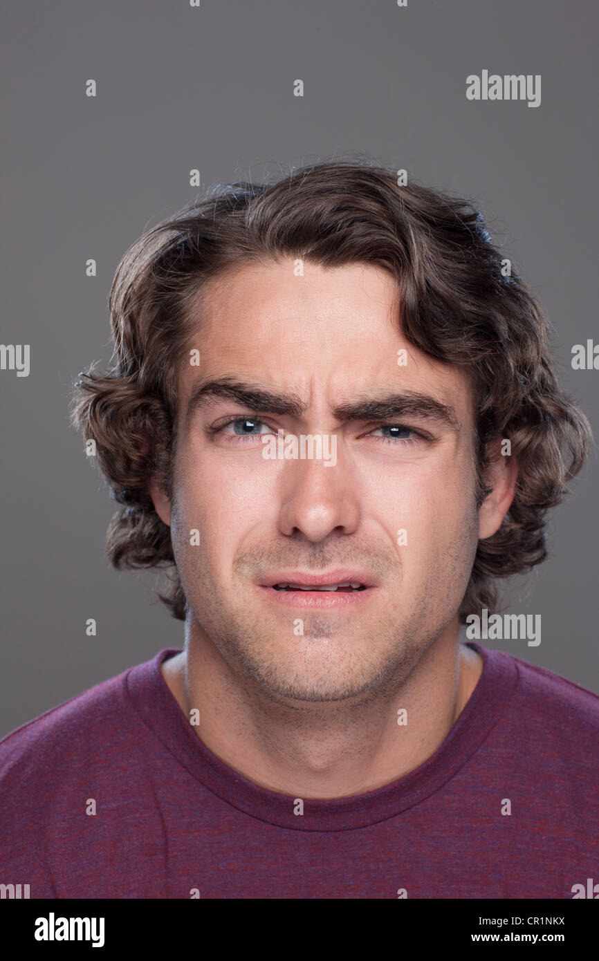 Studio shot of confused young man Stock Photo - Alamy