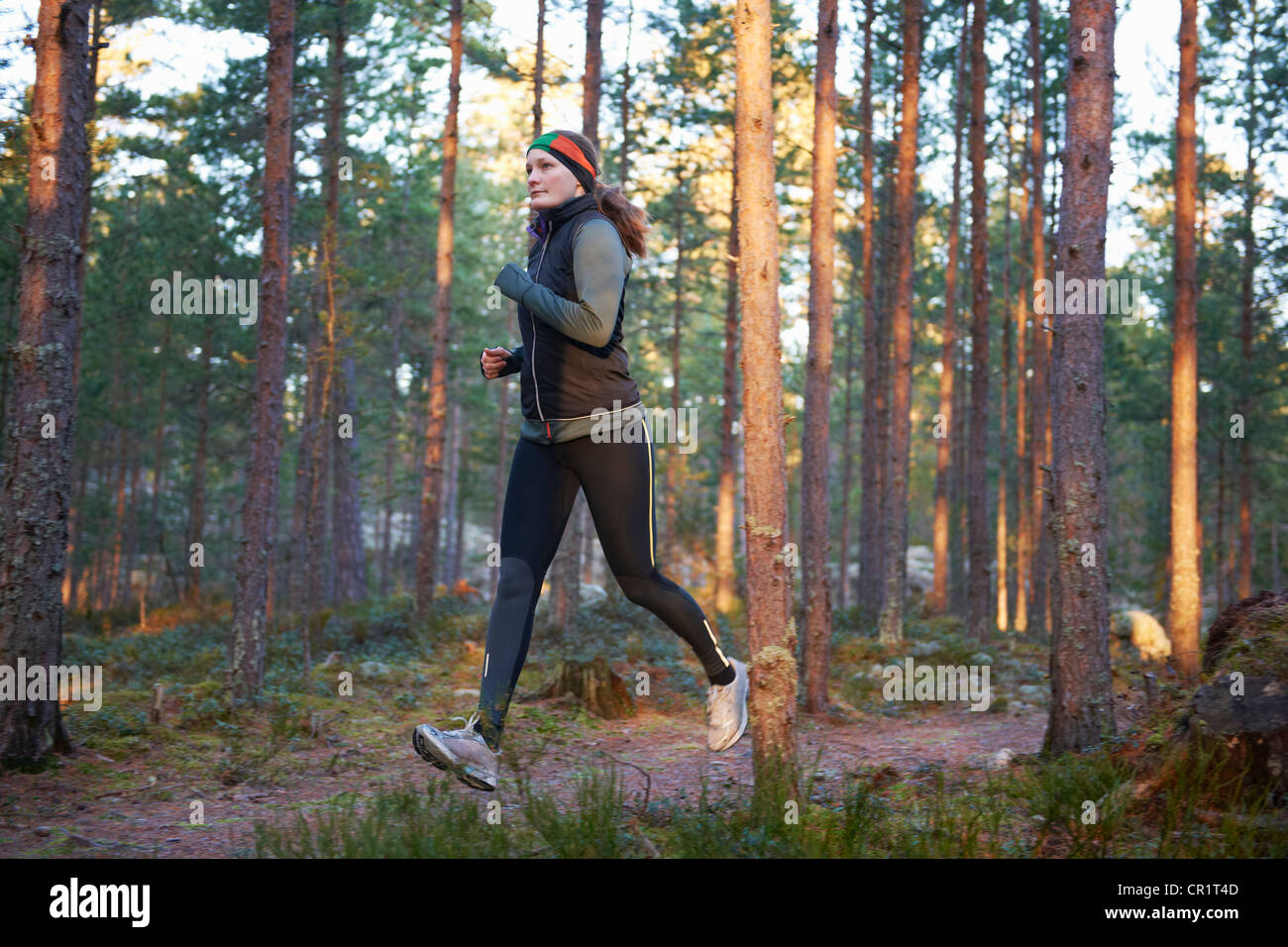 Woman running in forest Stock Photo - Alamy