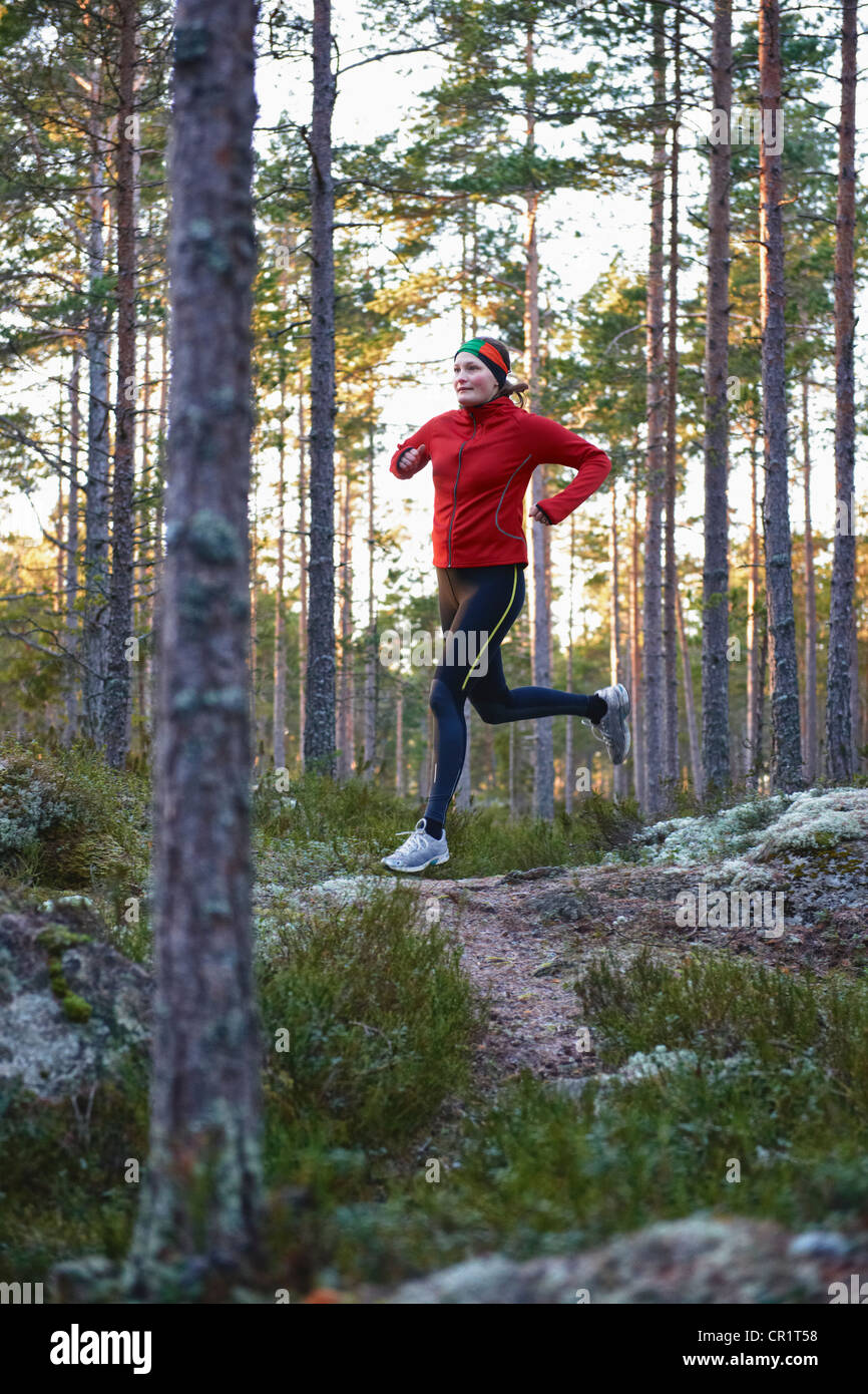 Woman running in forest Stock Photo - Alamy