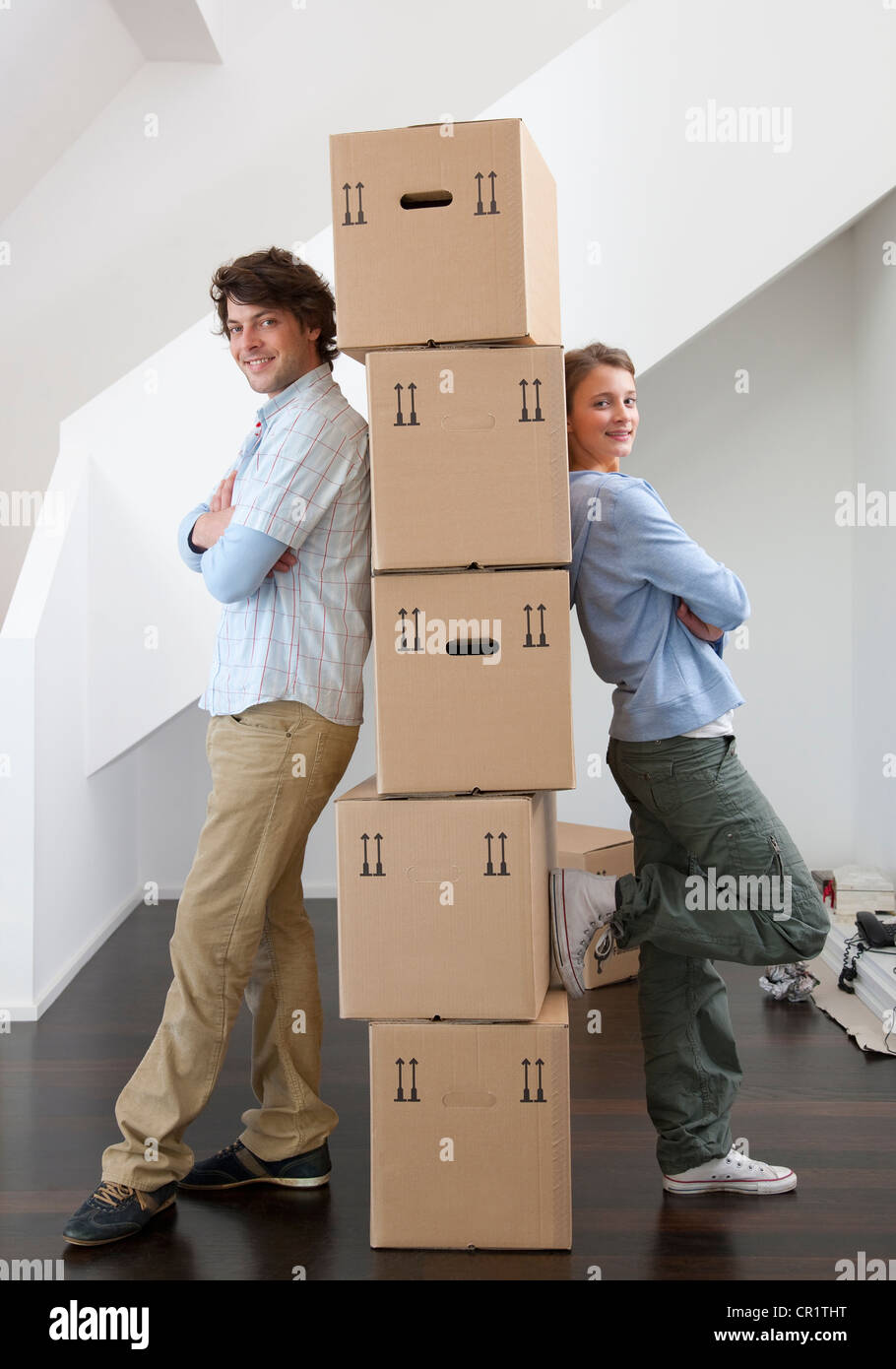 Couple with stack of cardboard boxes Stock Photo - Alamy
