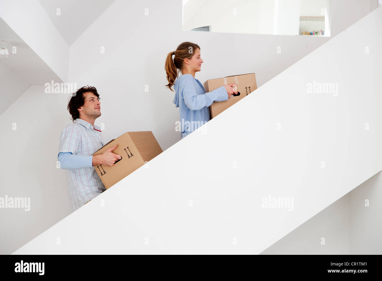 Couple carrying cardboard boxes Stock Photo - Alamy