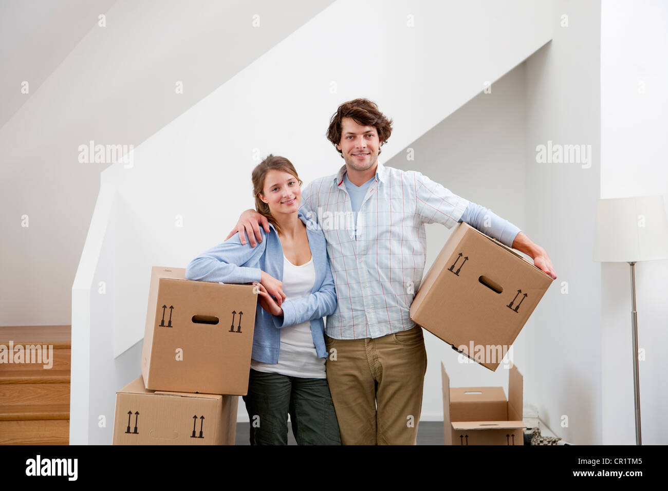 Couple carrying cardboard boxes Stock Photo - Alamy