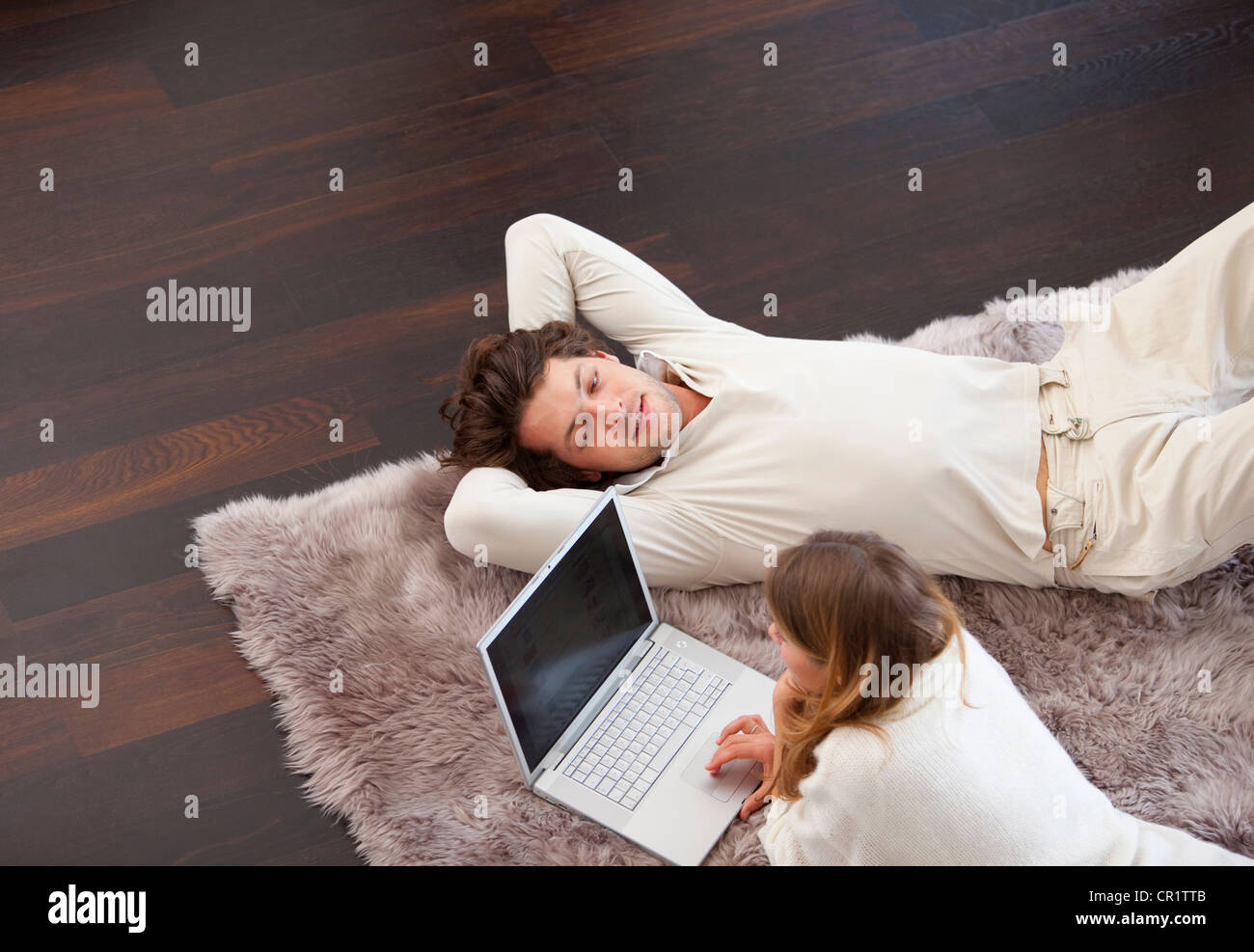 Couple relaxing together on rug Stock Photo - Alamy