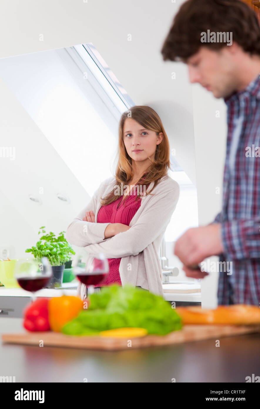 Woman watching boyfriend cook Stock Photo - Alamy