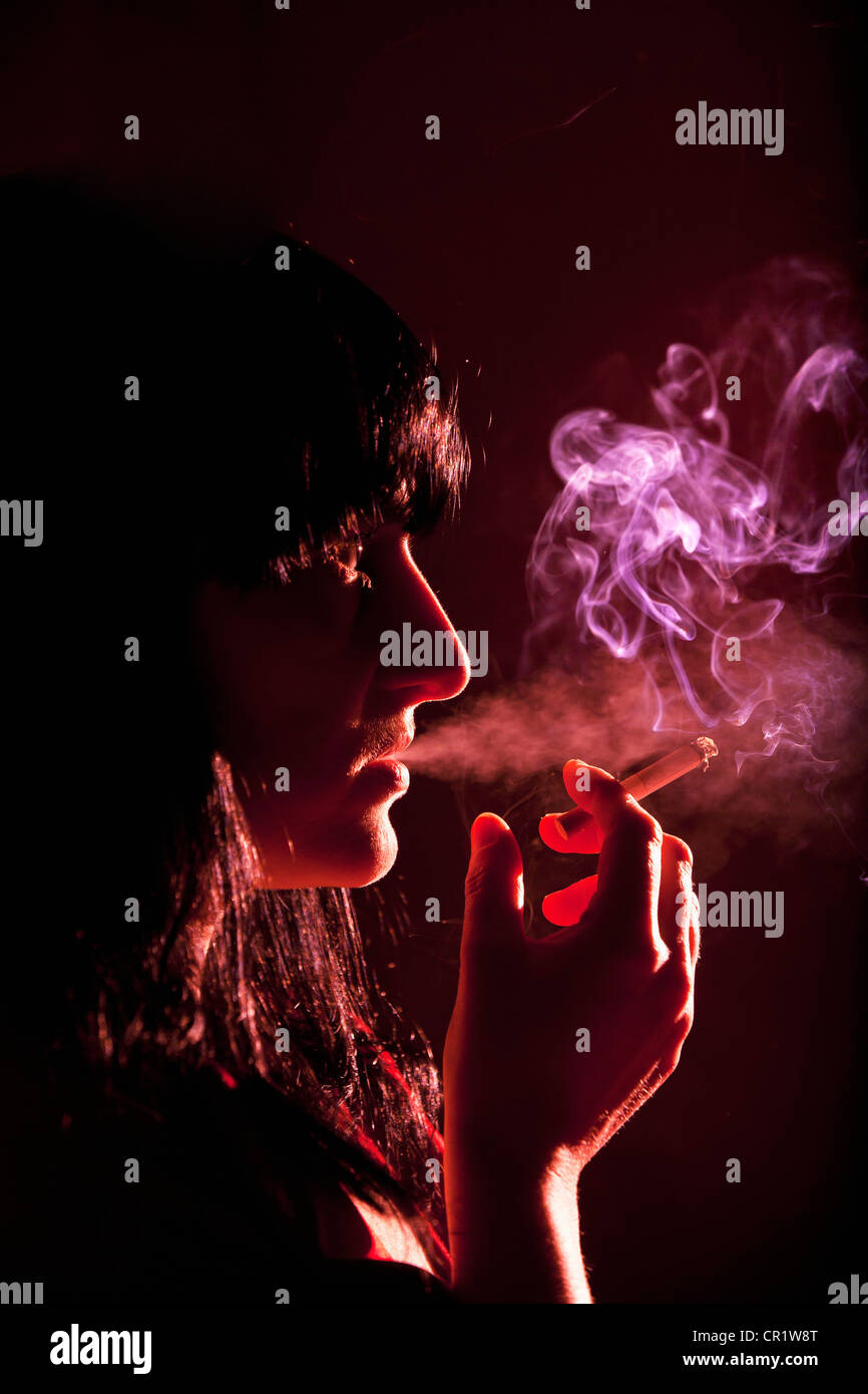Illuminated profile of woman smoking Stock Photo - Alamy