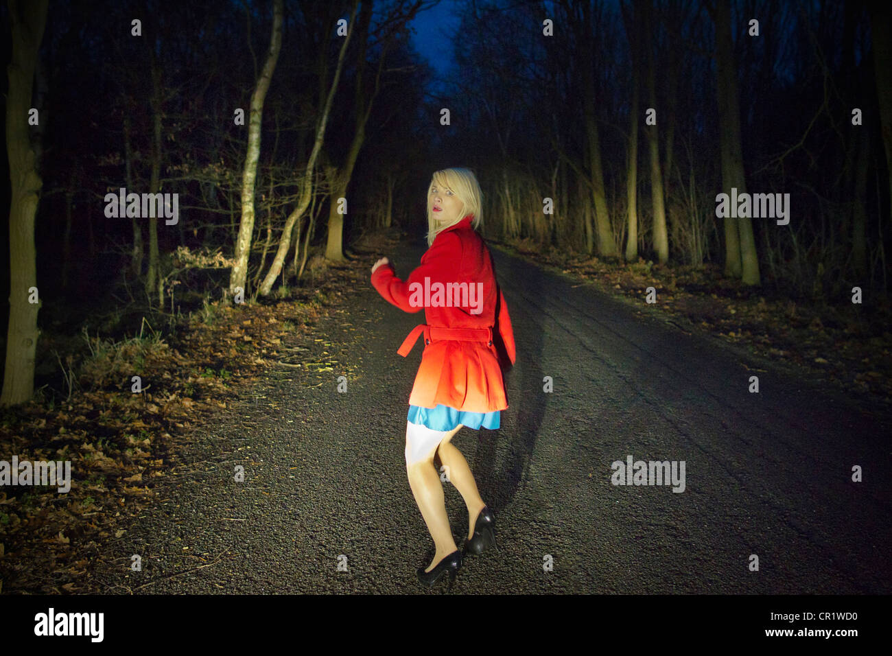 Woman running in fear in woods at night Stock Photo - Alamy