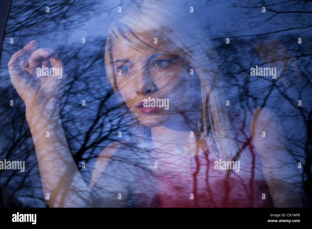 Woman peering out car window in woods Stock Photo - Alamy