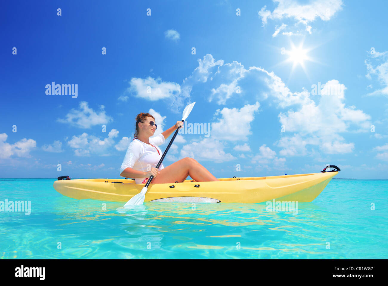 A female kayaking on a sunny day, Kuredu island, Maldives, Lhaviyani ...