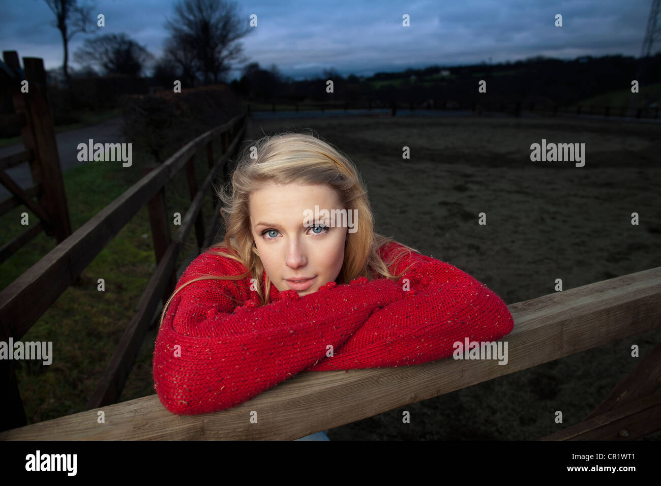 Teenage girl leaning on wooden fence Stock Photo - Alamy