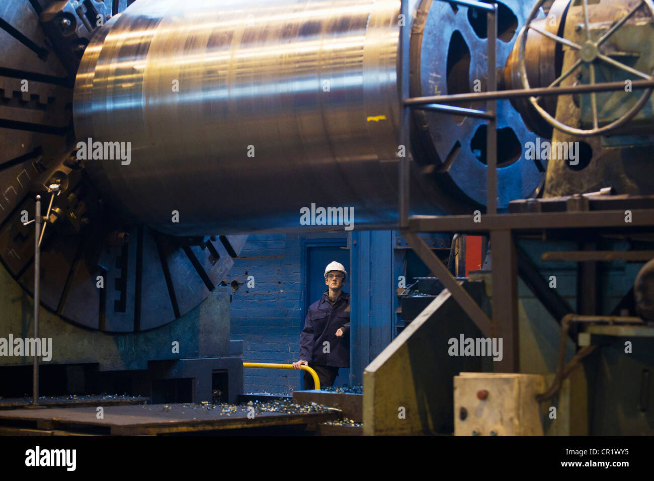 Worker with machinery in steel forge Stock Photo - Alamy
