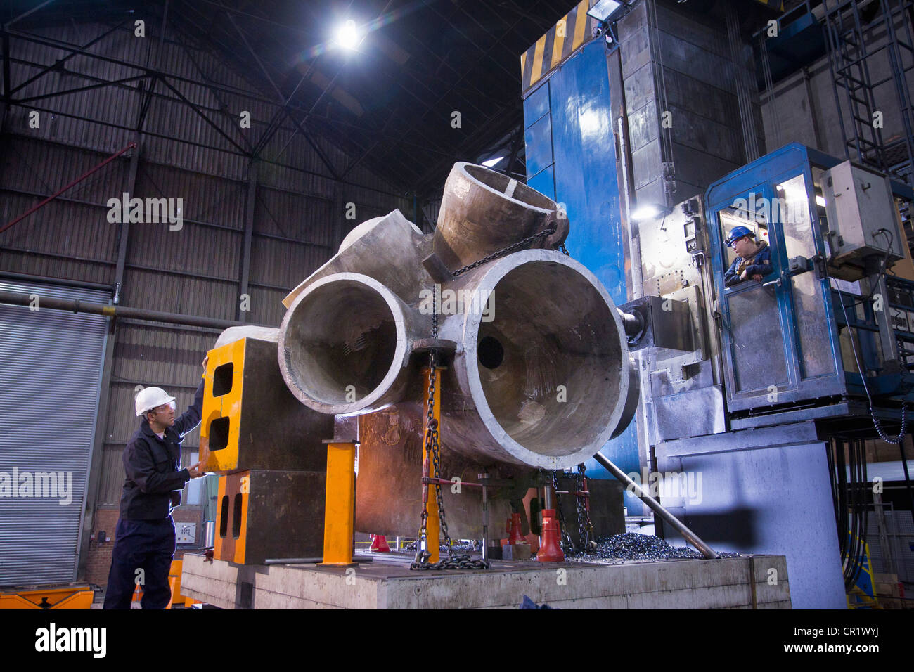 Worker using machinery in steel forge Stock Photo - Alamy