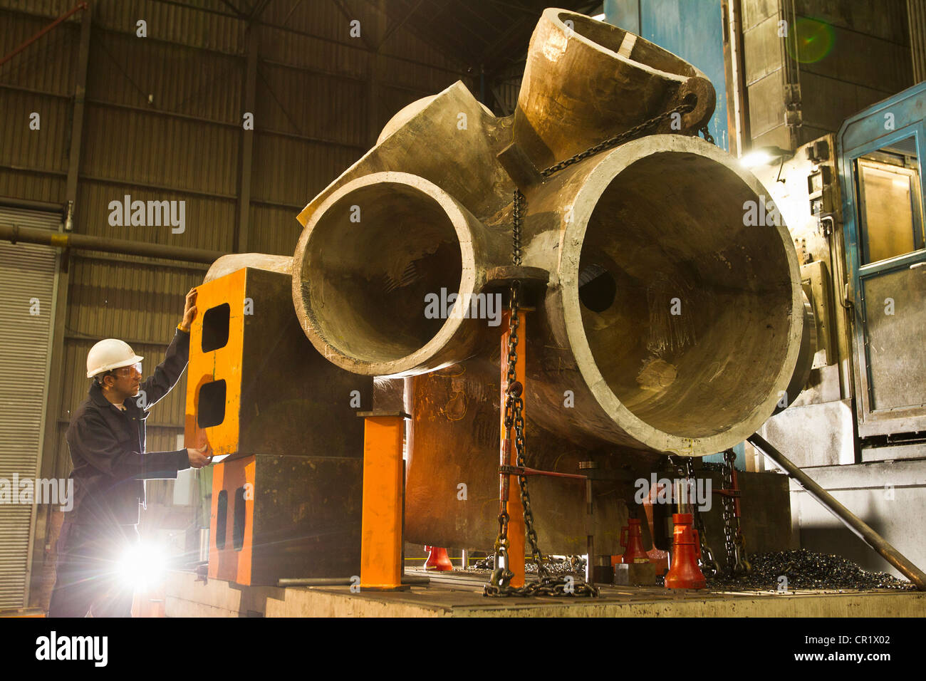 Worker using machinery in steel forge Stock Photo - Alamy
