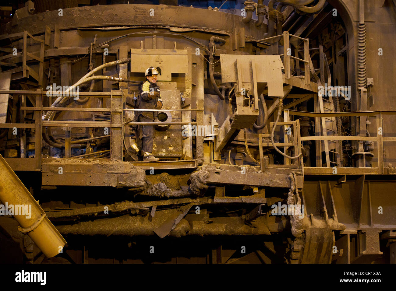 Worker using machinery in steel forge Stock Photo - Alamy