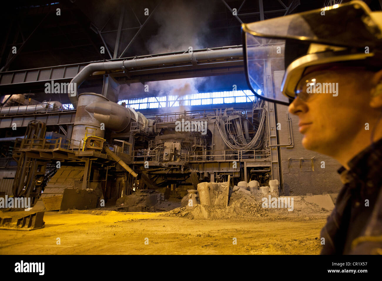 Worker walking in steel forge Stock Photo - Alamy