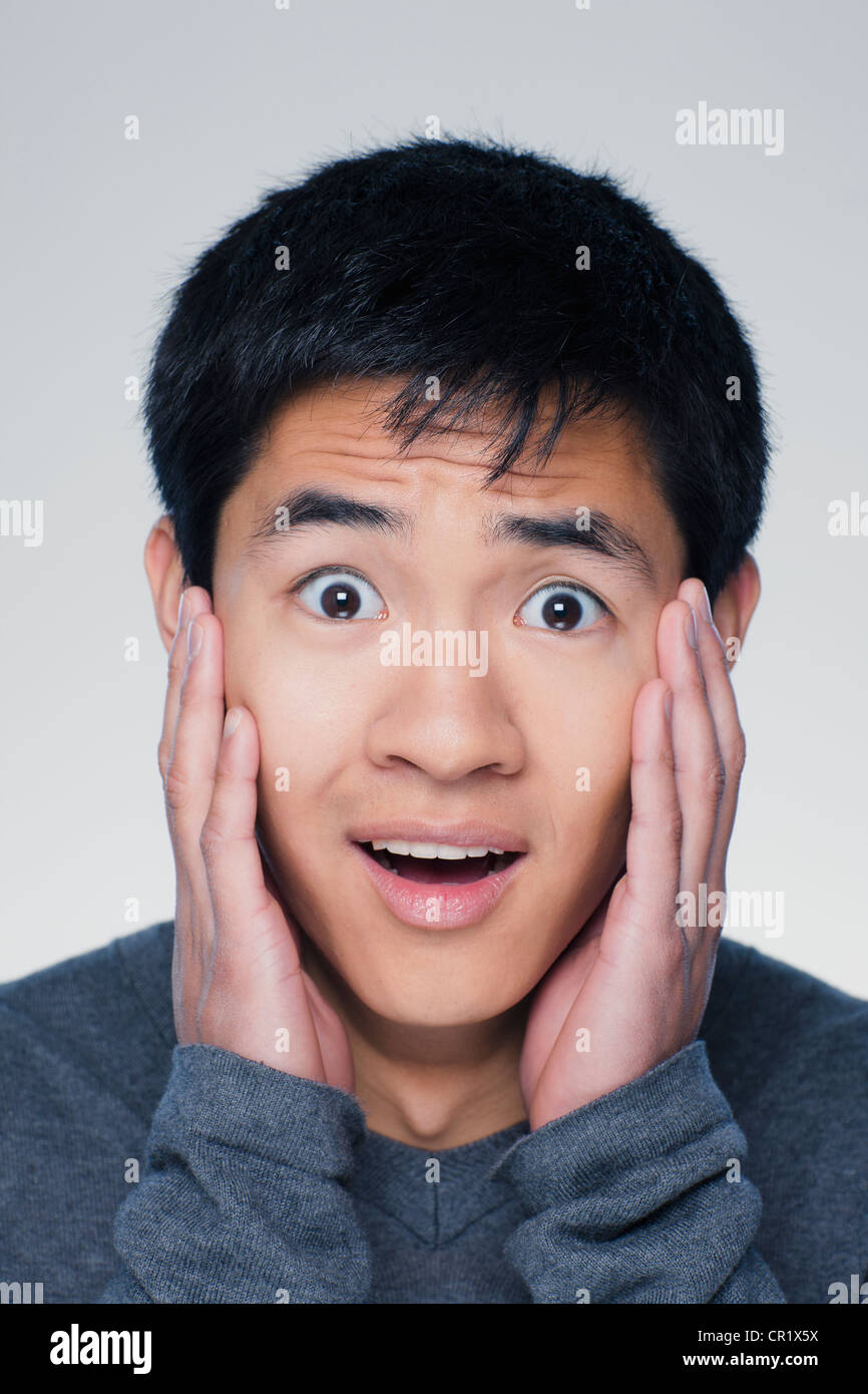 Studio portrait of young man with head in hands Stock Photo - Alamy