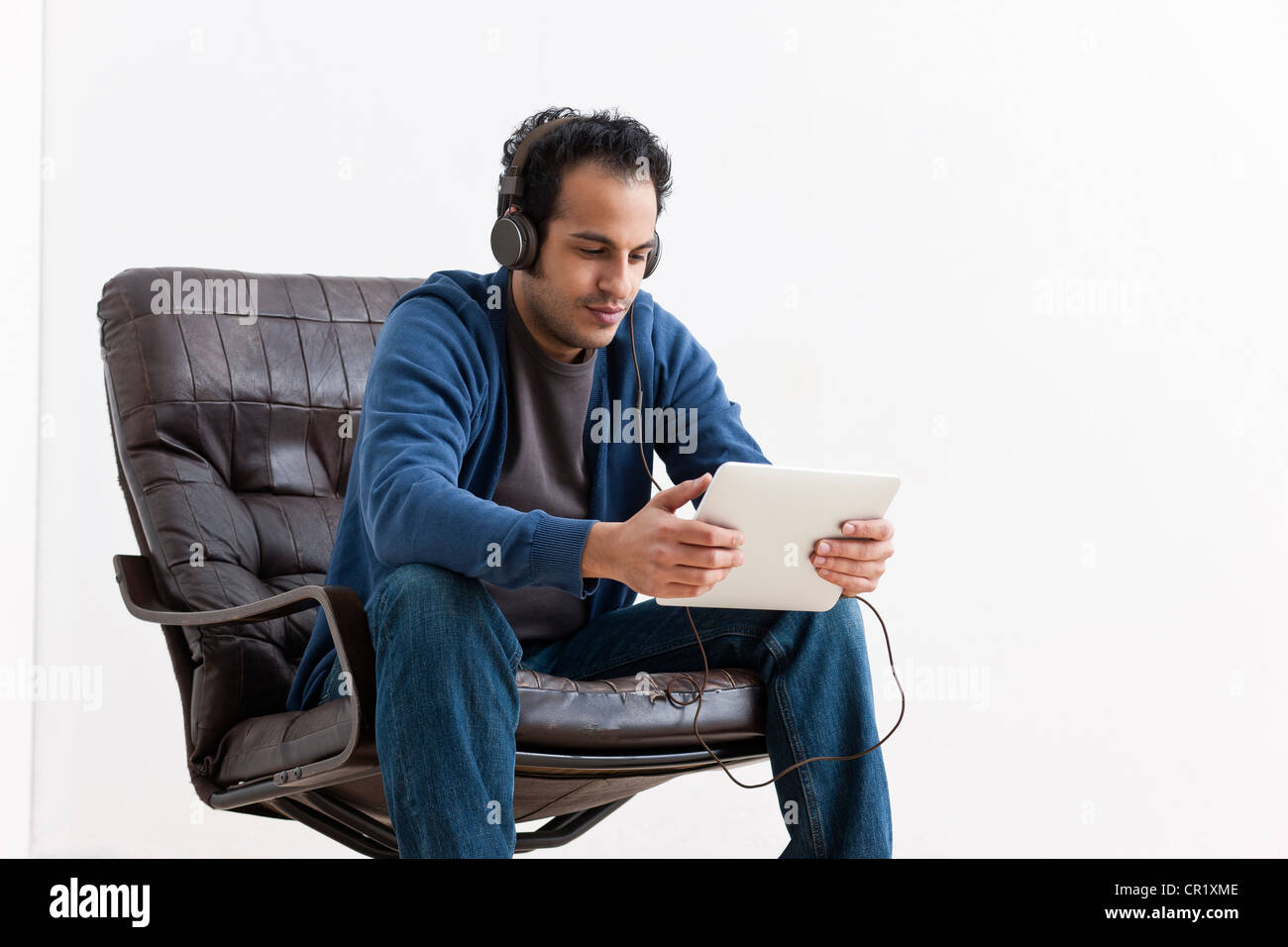 Man listening to tablet computer Stock Photo - Alamy
