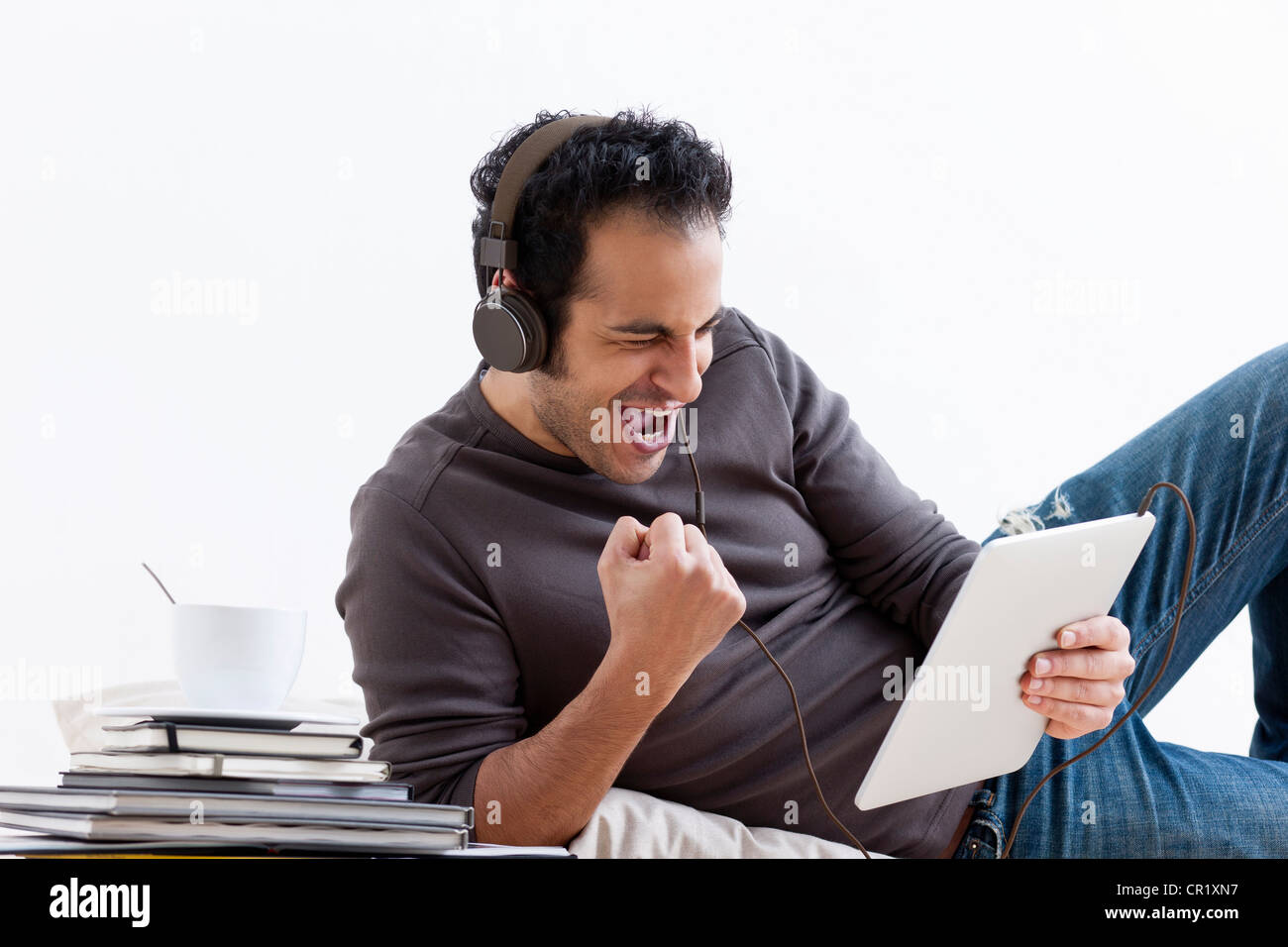 Man listening to tablet computer Stock Photo - Alamy