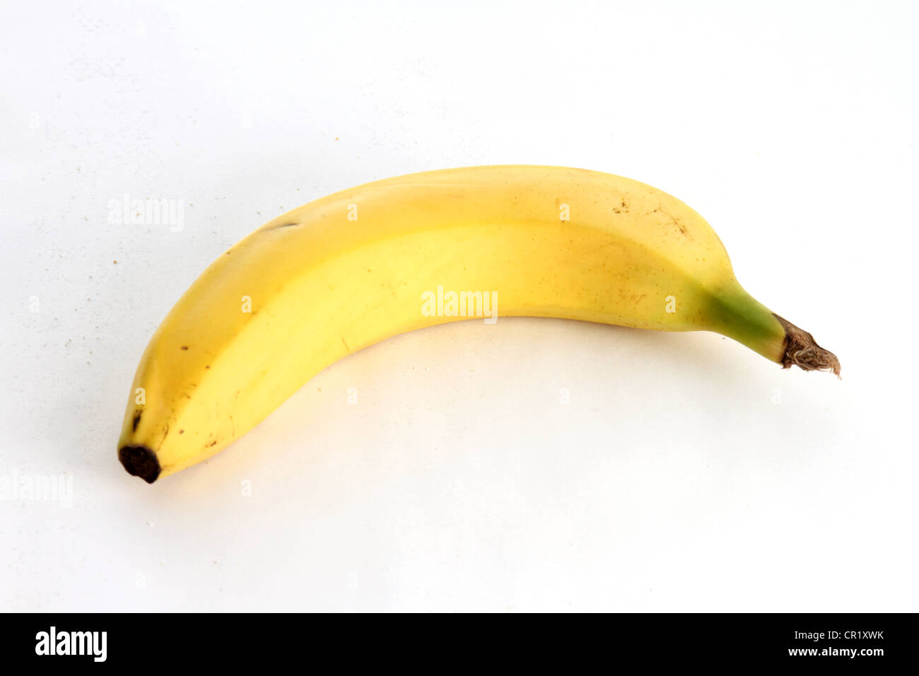 Single banana sitting on a white background Stock Photo - Alamy
