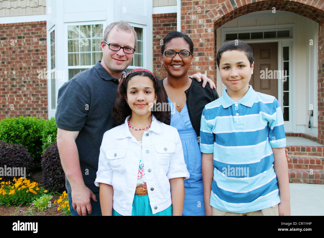 Family standing in front of their house Stock Photo - Alamy