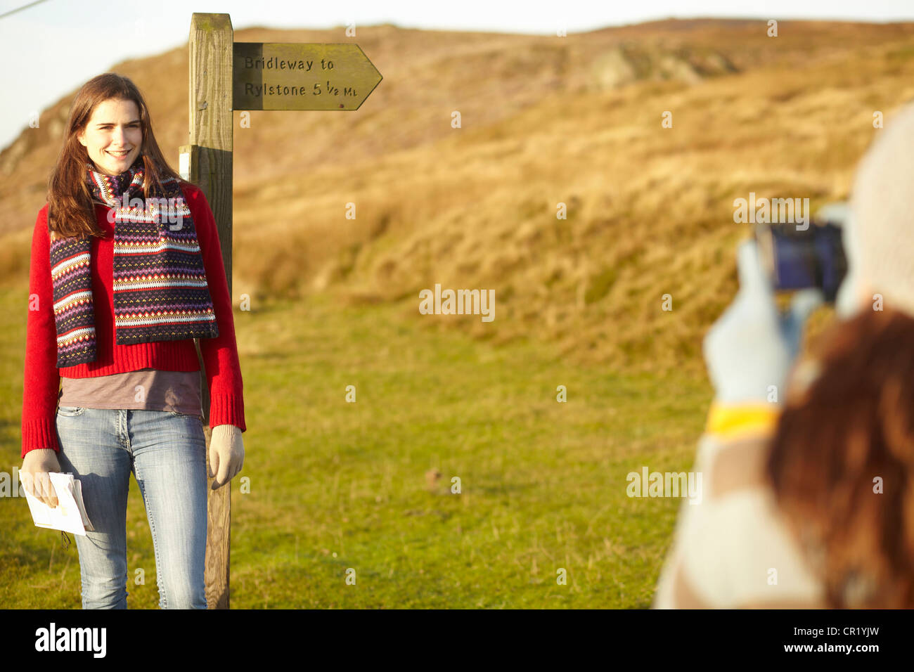 Woman taking picture of friend at post Stock Photo - Alamy
