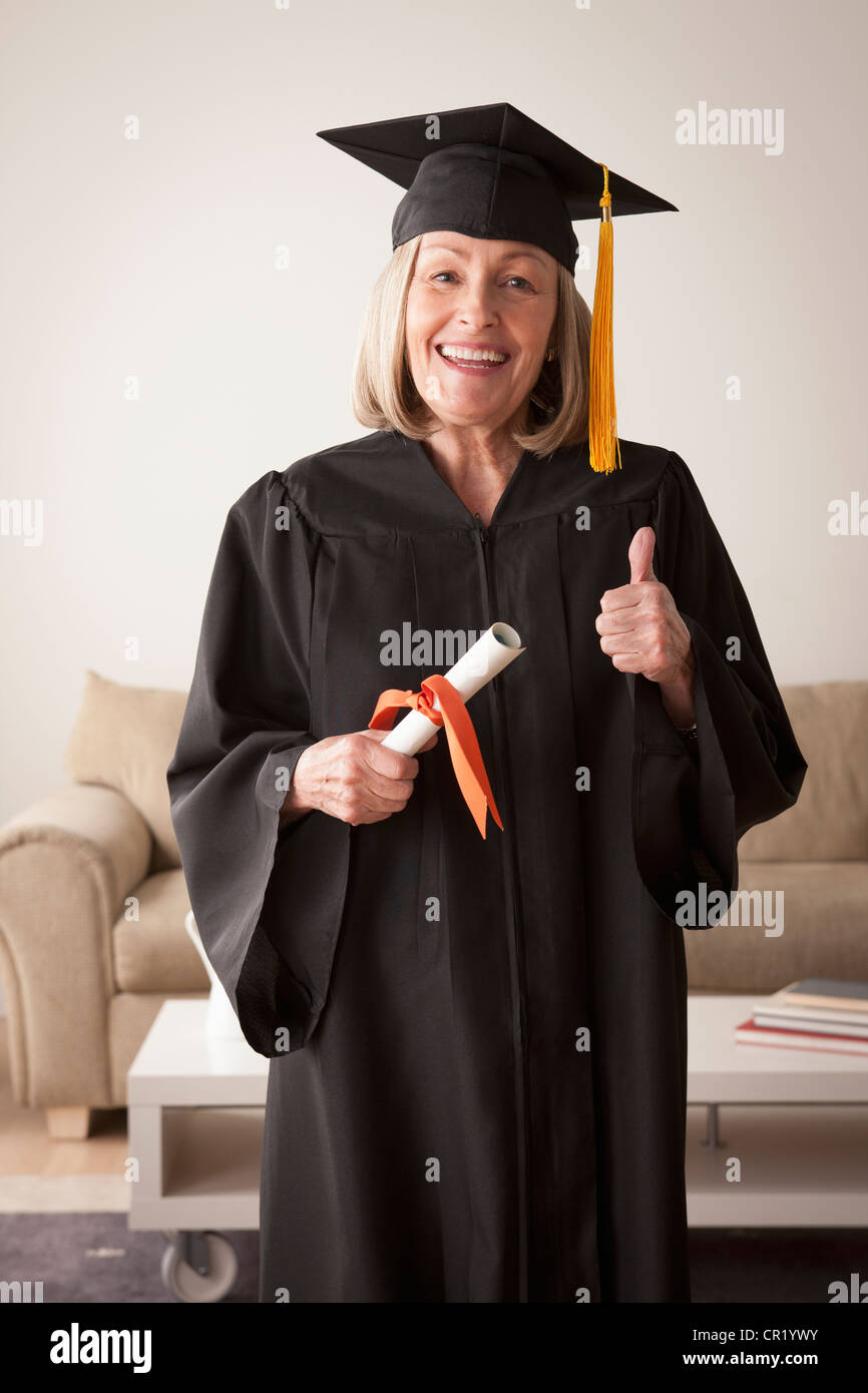 USA, California, Los Angeles, Senior woman wearing graduation gown ...