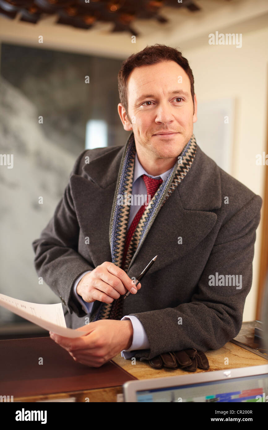 Businessman with paper at front desk Stock Photo - Alamy
