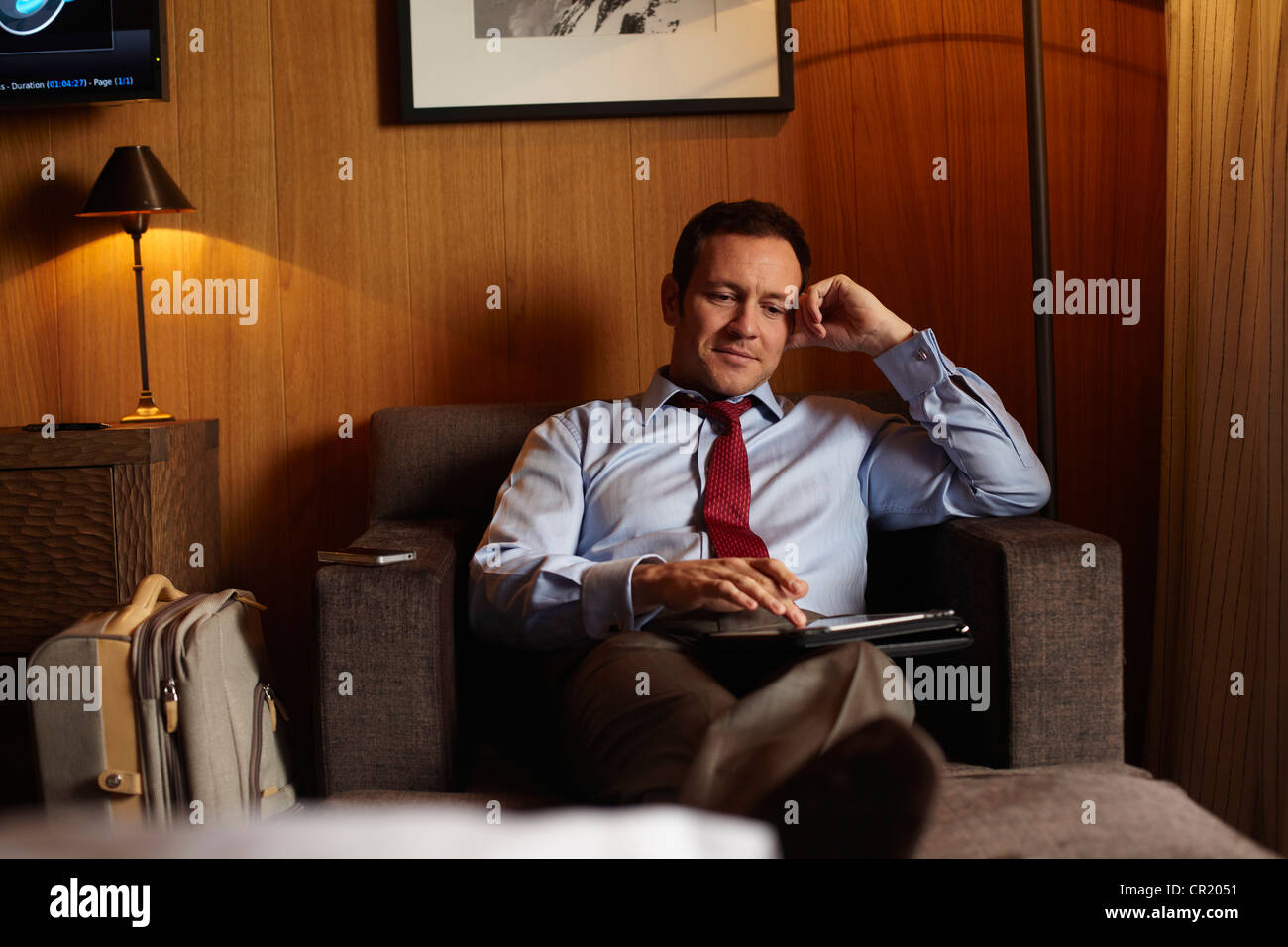 Businessman using tablet in hotel room Stock Photo - Alamy