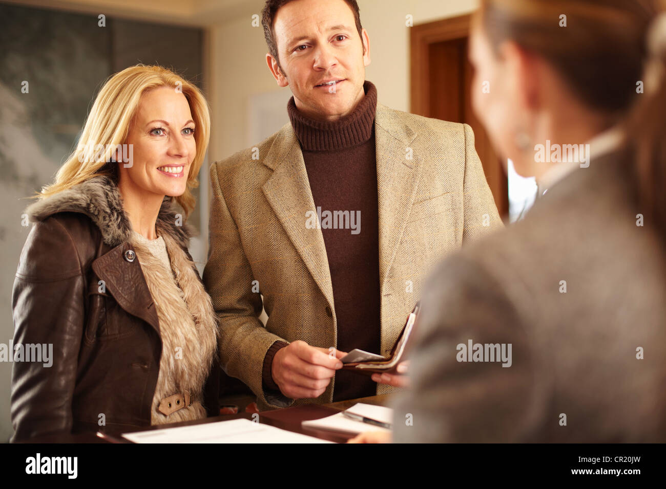 Couple checking in to hotel Stock Photo - Alamy