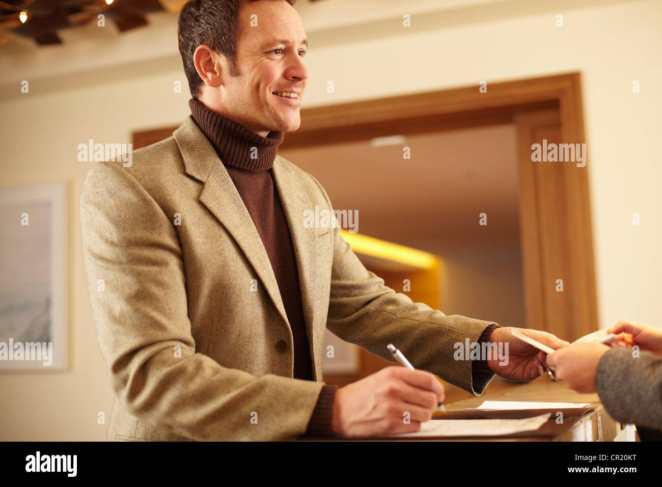 Man checking in to hotel Stock Photo - Alamy