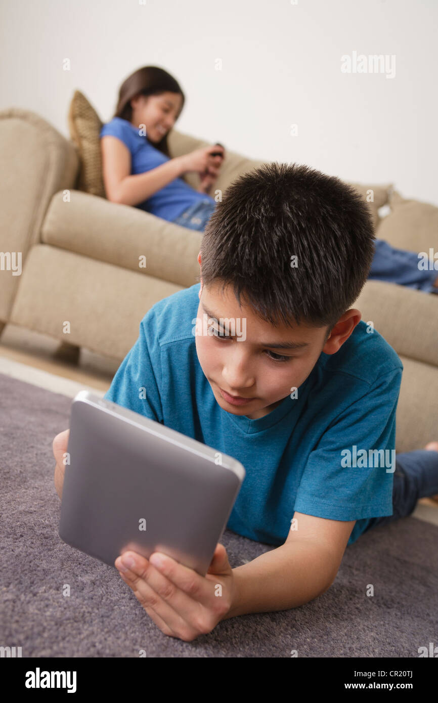 USA, California, Los Angeles, Boy using iPad lying on floor Stock Photo ...