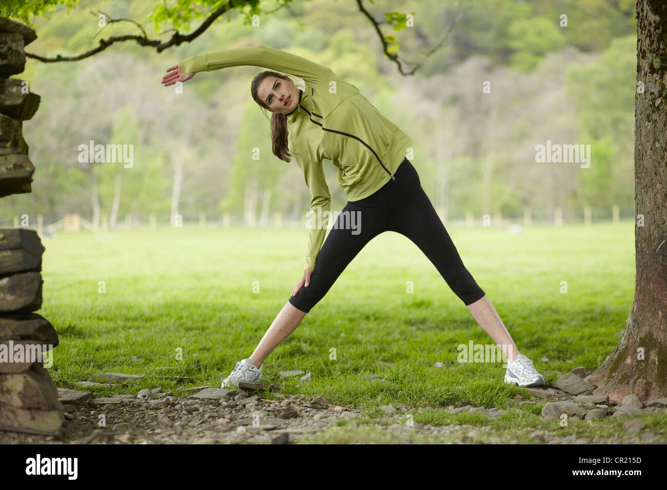 Runner stretching in rural field Stock Photo - Alamy