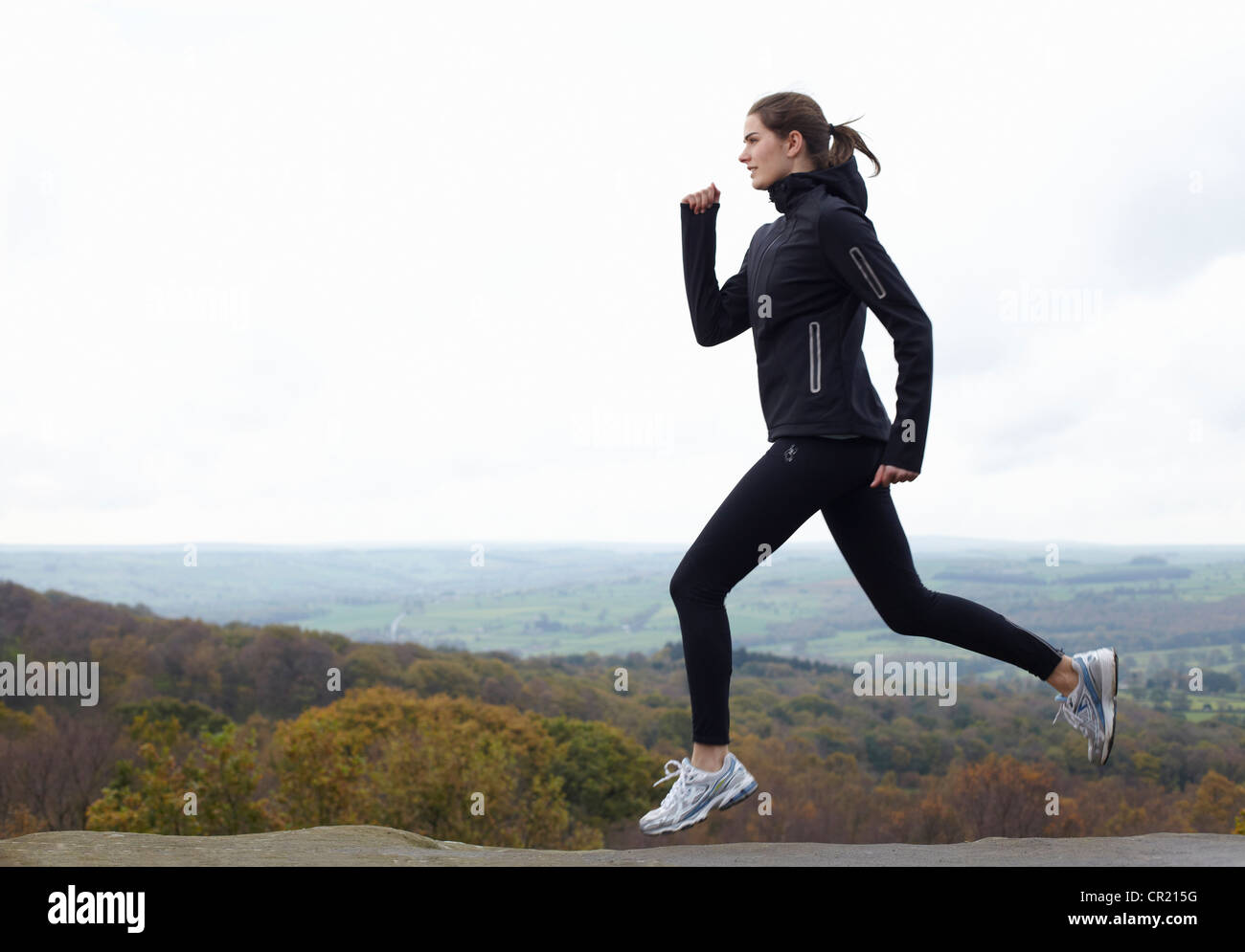 Woman running on rural hill Stock Photo - Alamy