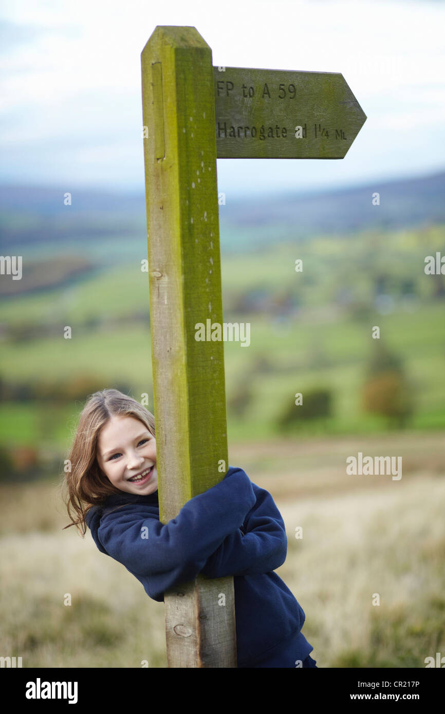 Smiling girl hugging road sign Stock Photo - Alamy