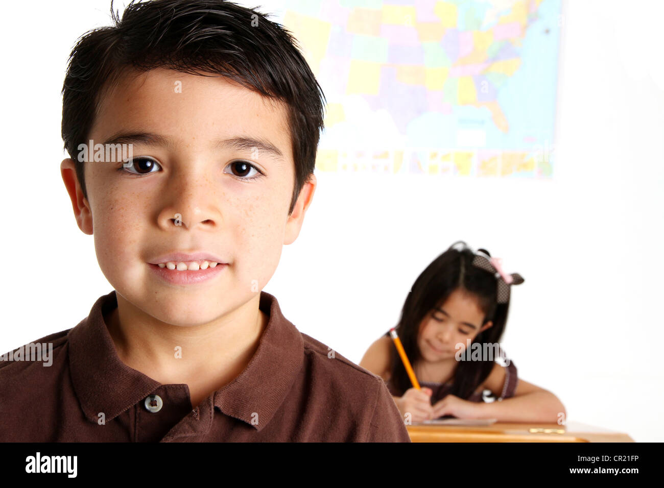 Young Children in School Working at Desk Stock Photo - Alamy