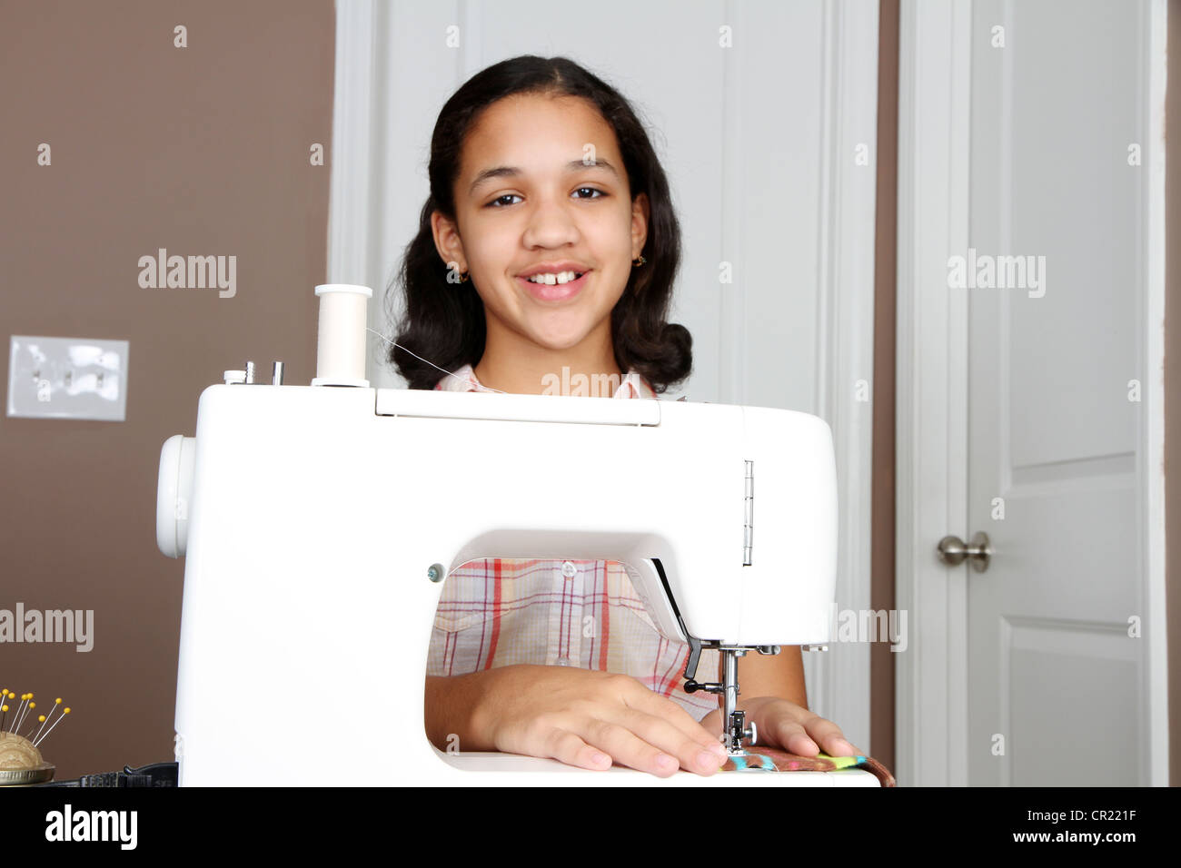 Girl using a sewing machine to make crafts Stock Photo - Alamy