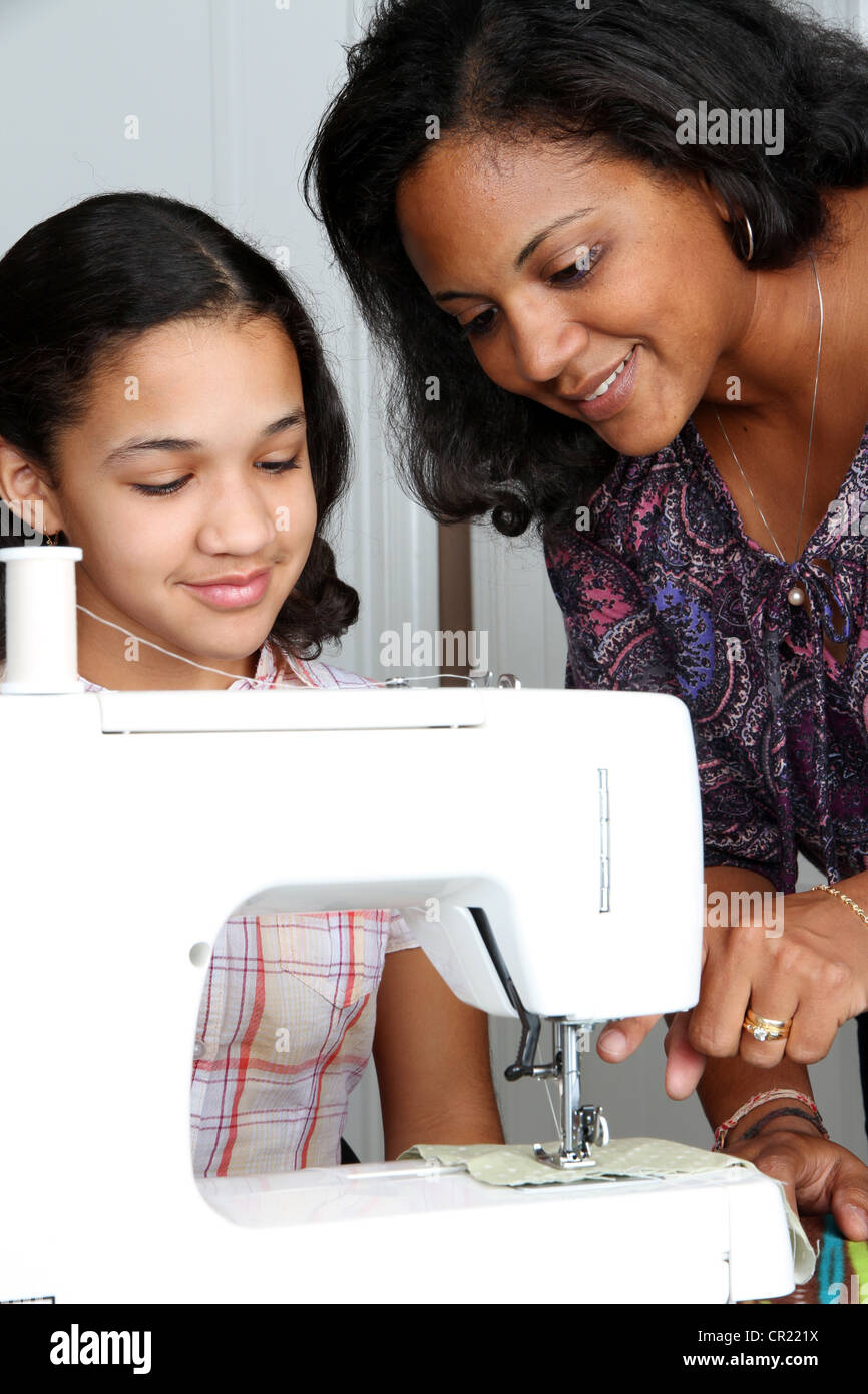 Girl and mother using a sewing machine to make crafts Stock Photo - Alamy