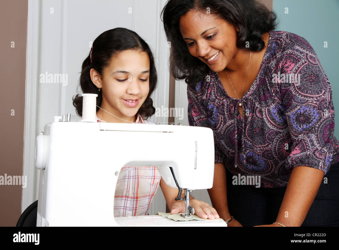 Girl and mother using a sewing machine to make crafts Stock Photo - Alamy