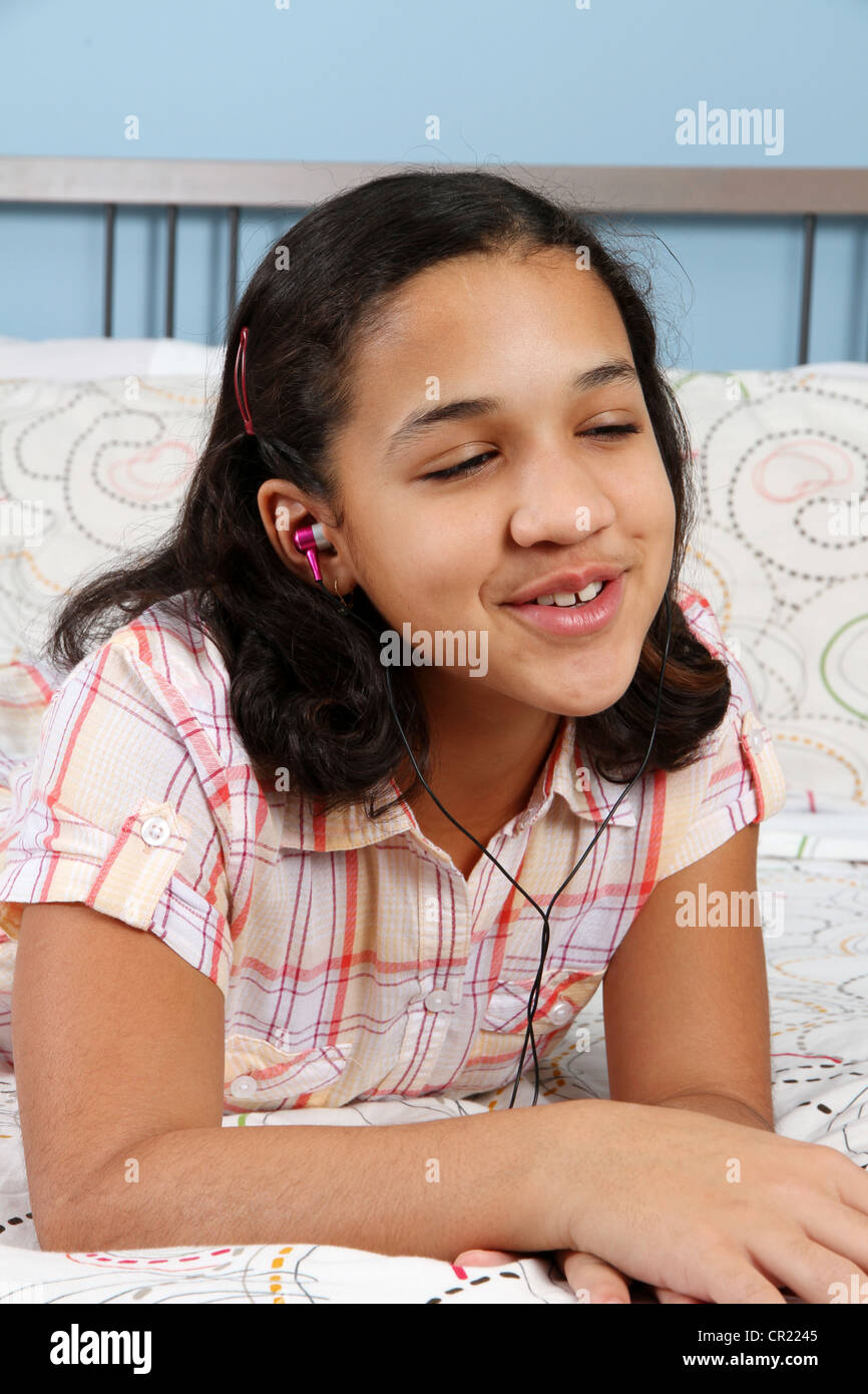 Girl singing songs while laying on bed Stock Photo - Alamy