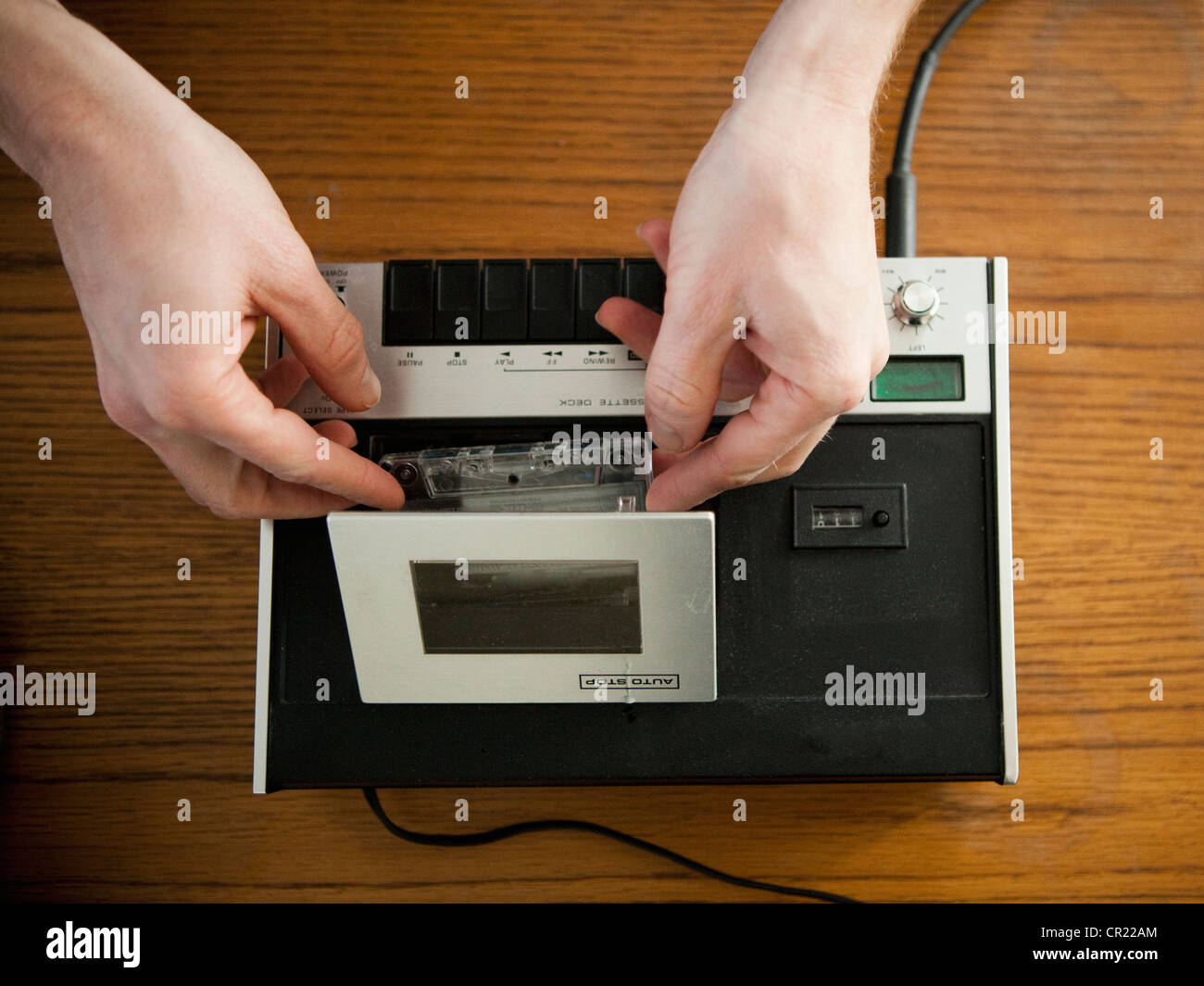 Close-up view of human hands putting tape into old-fashioned tape ...
