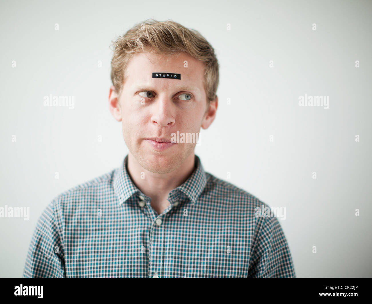 Studio shot of young man with black concept label on forehead Stock ...